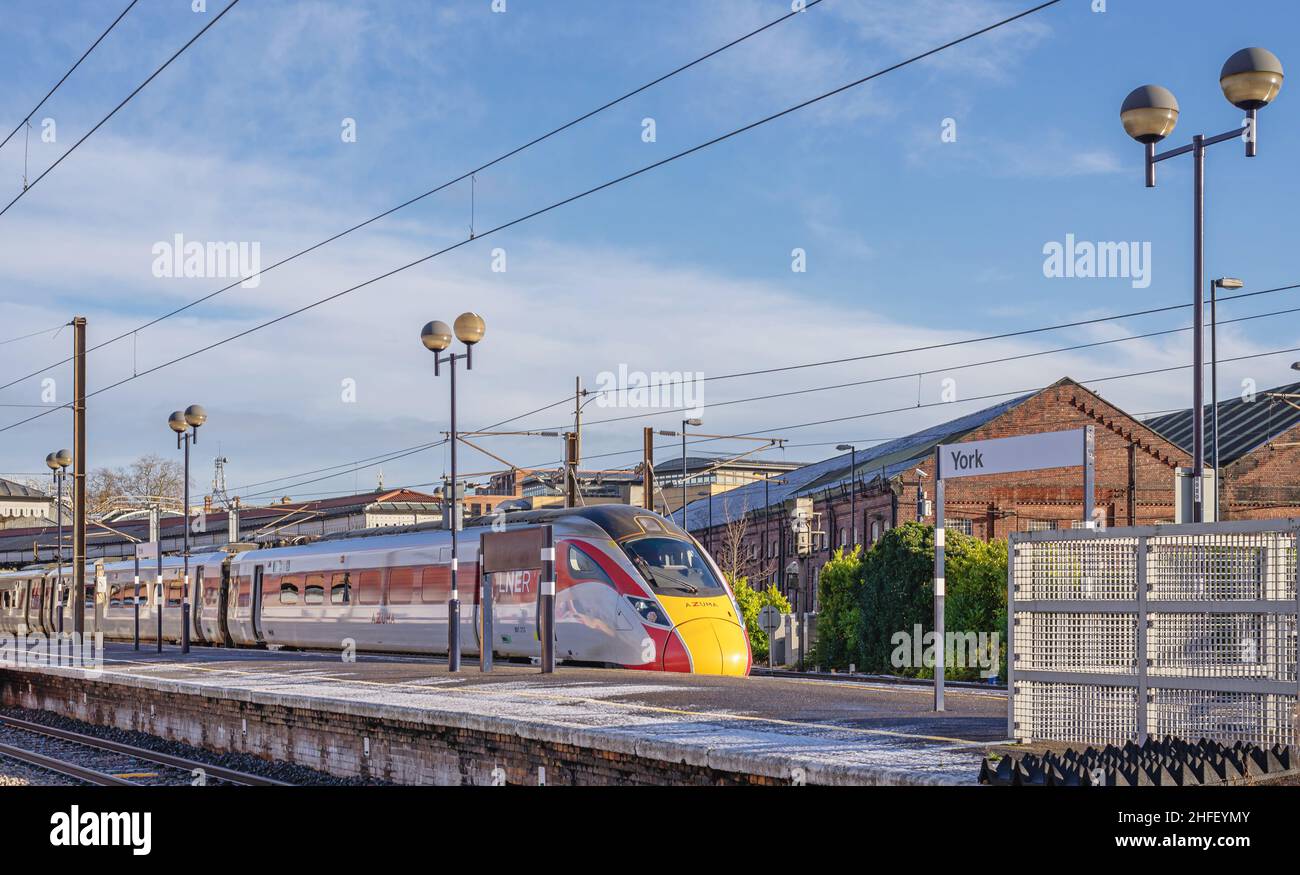 A train rests at a railway station platform with a light dusting of ...