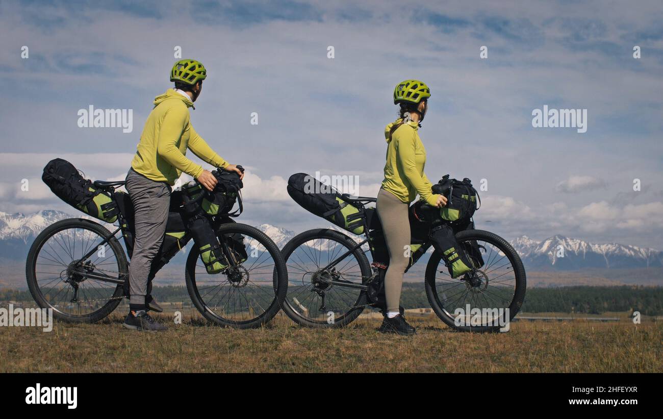 The man and woman travel on mixed terrain cycle touring with ...