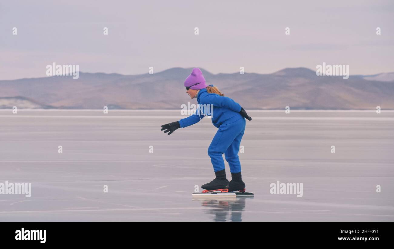 The girl train on ice speed skating. The child skates in the winter in ...
