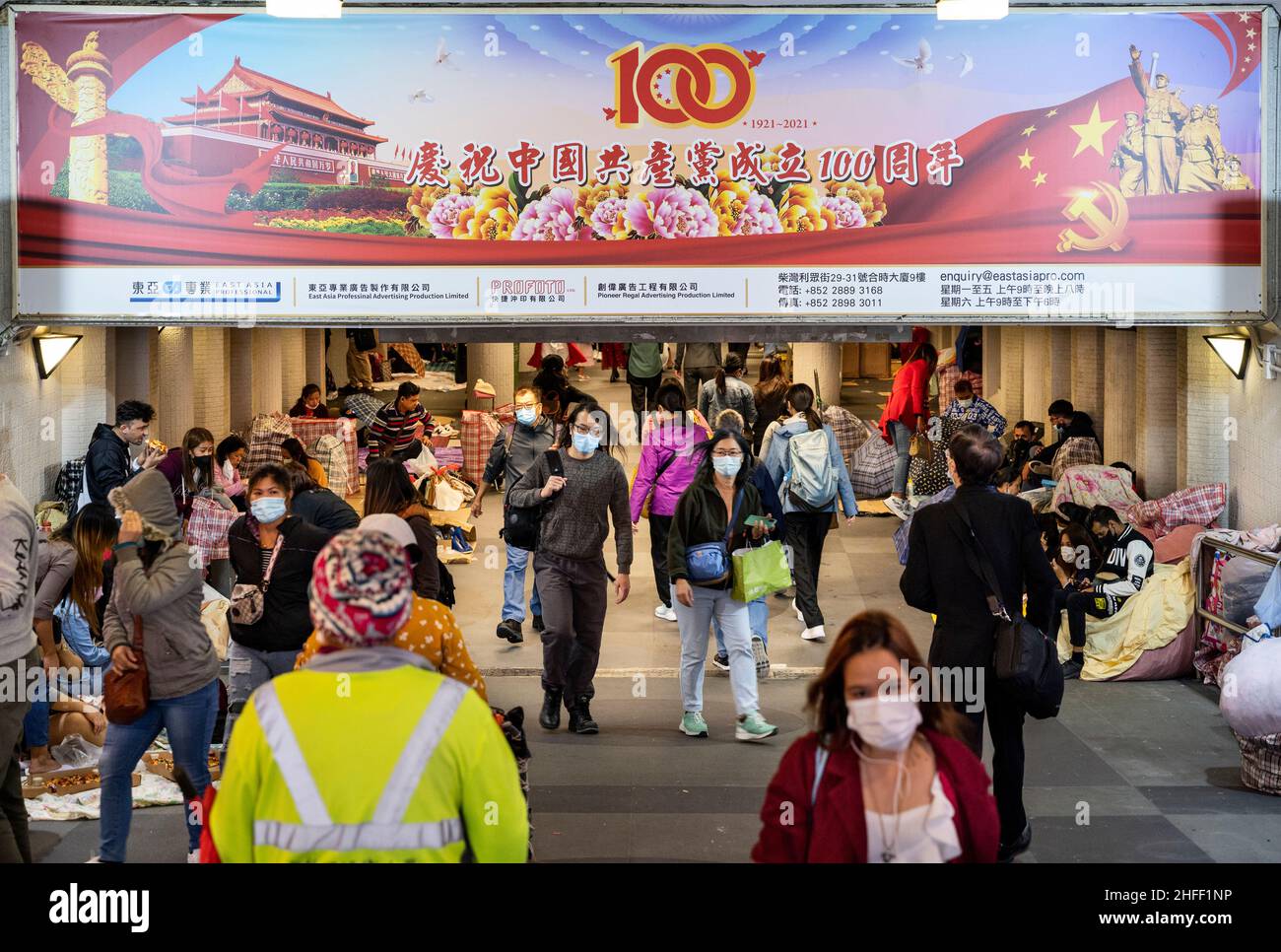 Pedestrians walk past a banner advertising and commemorating the 100th ...