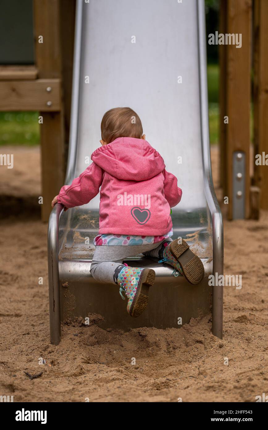 little girl on a slide in the playground Stock Photo - Alamy