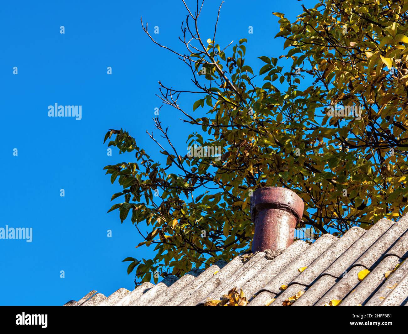 Chimney on the slate roof of the house against the blue sky Stock Photo ...