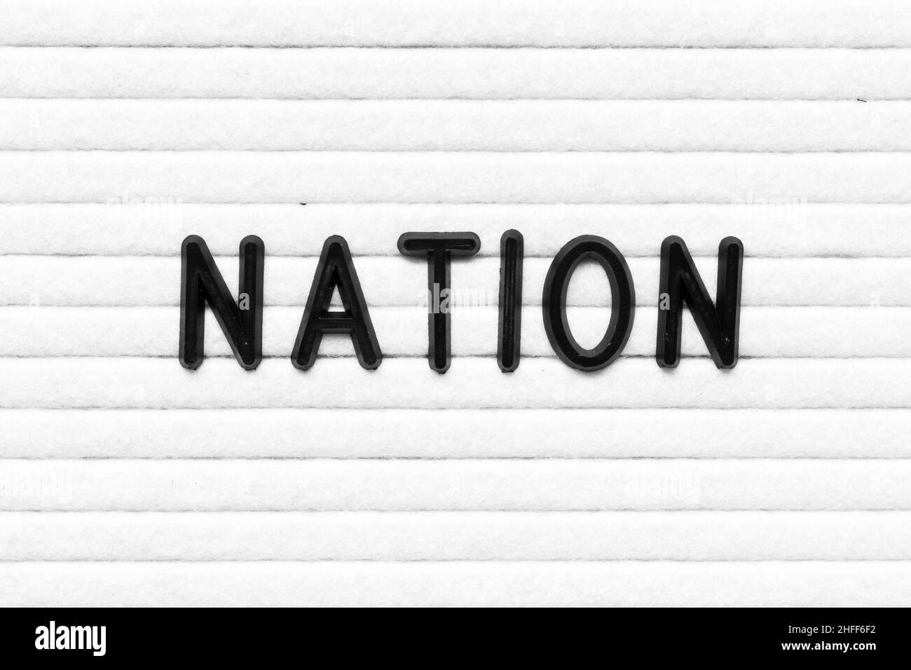 Black alphabet letter in word nation on white felt board background ...