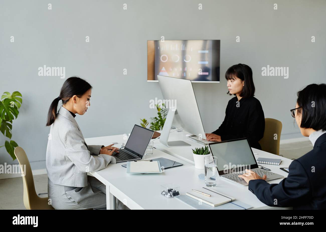 Minimal shot of group of Asian business people working with computers ...