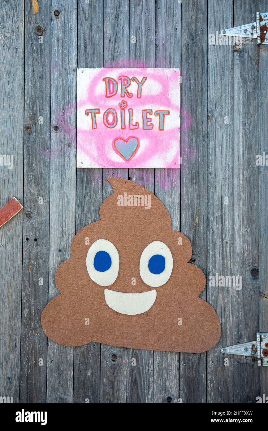 Poop emoji style sign on weathered wooden outdoor toilet door Stock ...