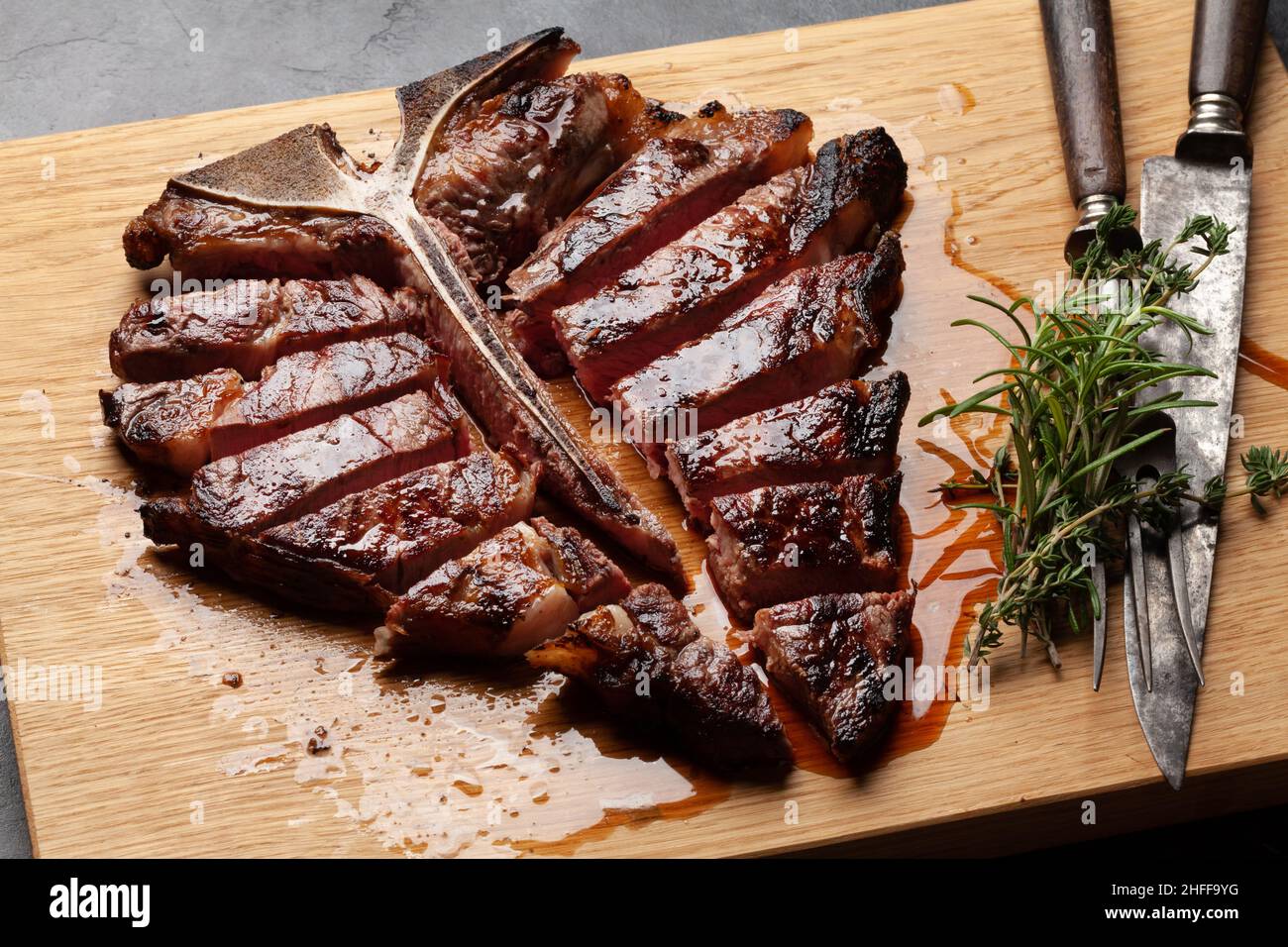 Grilled porterhouse beef steak. Sliced T-bone with herbs and spices ...