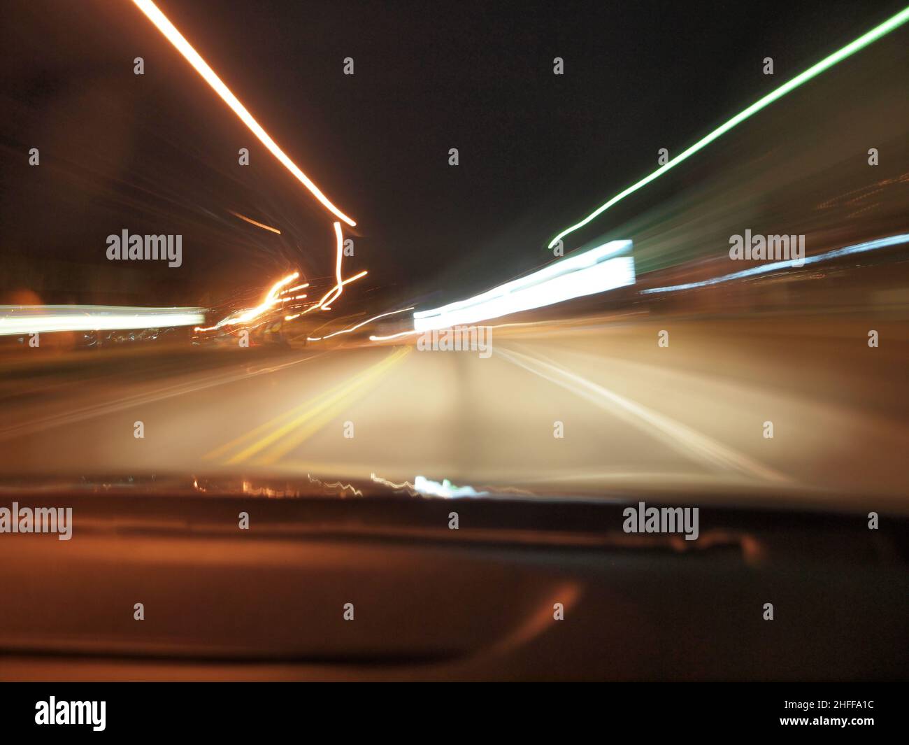 Time exposures of traffic speeding at night. Taken from car interior ...