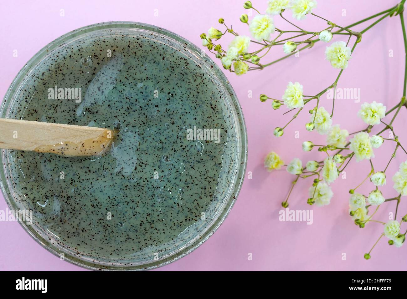 Body scrub with coffee top view. Body scrub in a plastic container on a ...