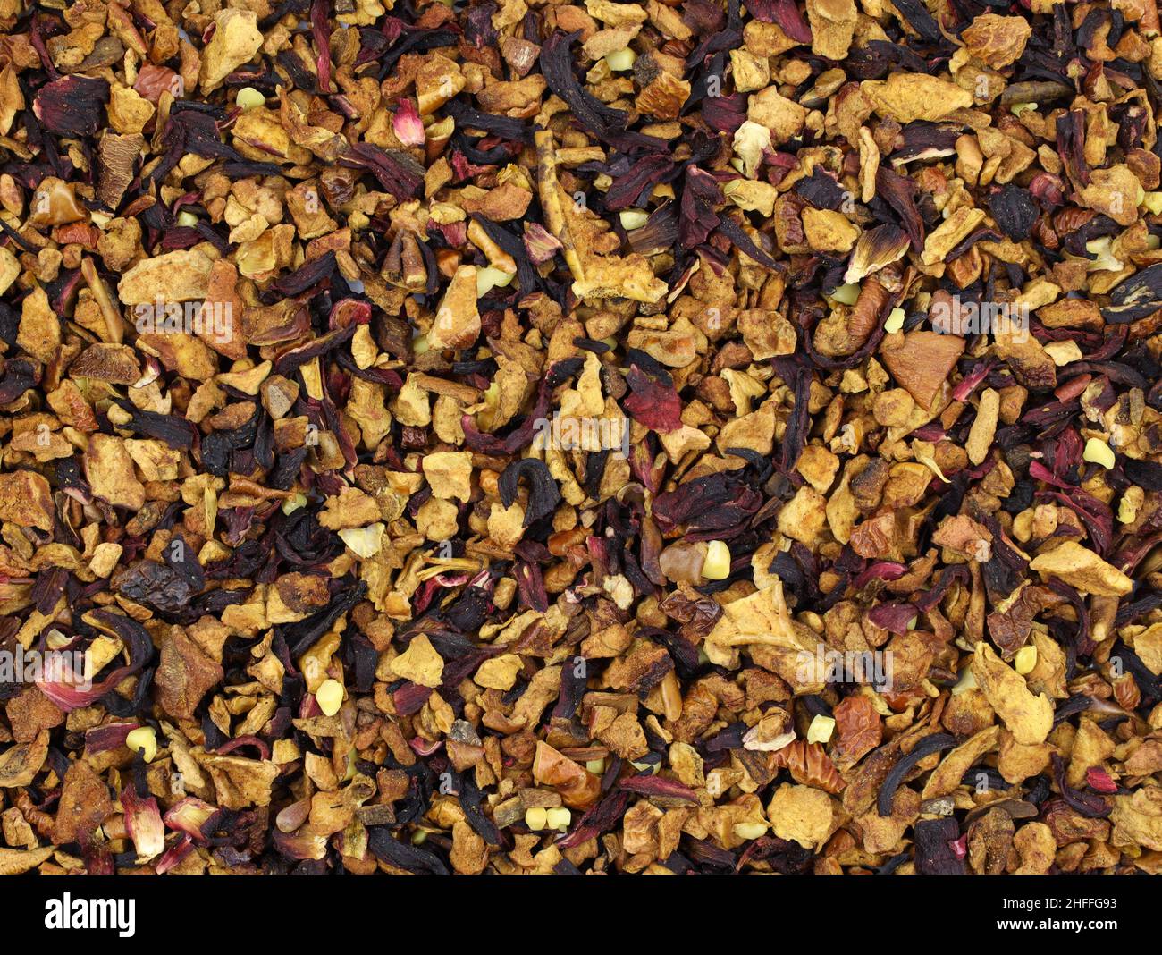 Red fruit tea with nut pieces and hibiscus leaves background. Aromatic ...