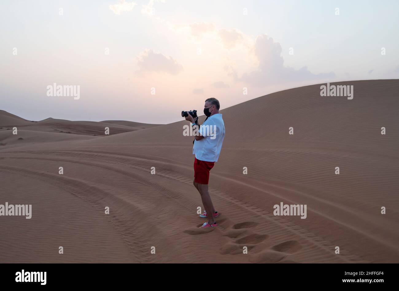 Man is a professional photographer with a camera in the desert among ...