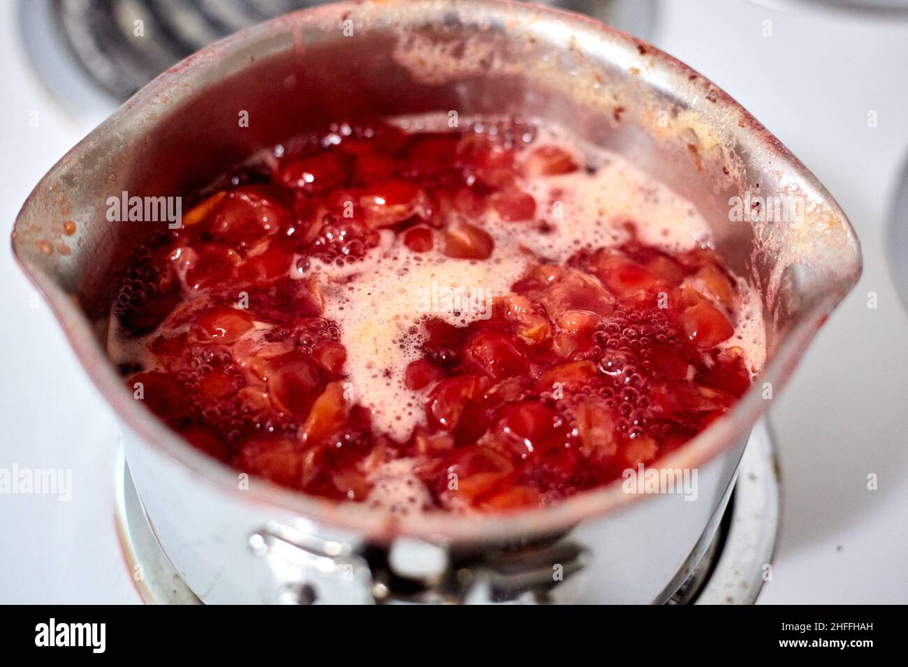 Cherry Compote Boiling in Chrome Stock Pot on White Electric Stove ...