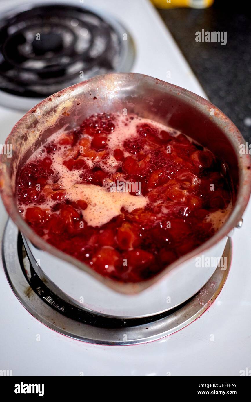 Wide View of Cherry Compote Boiling in Stock Pot on Electric Stove Near ...