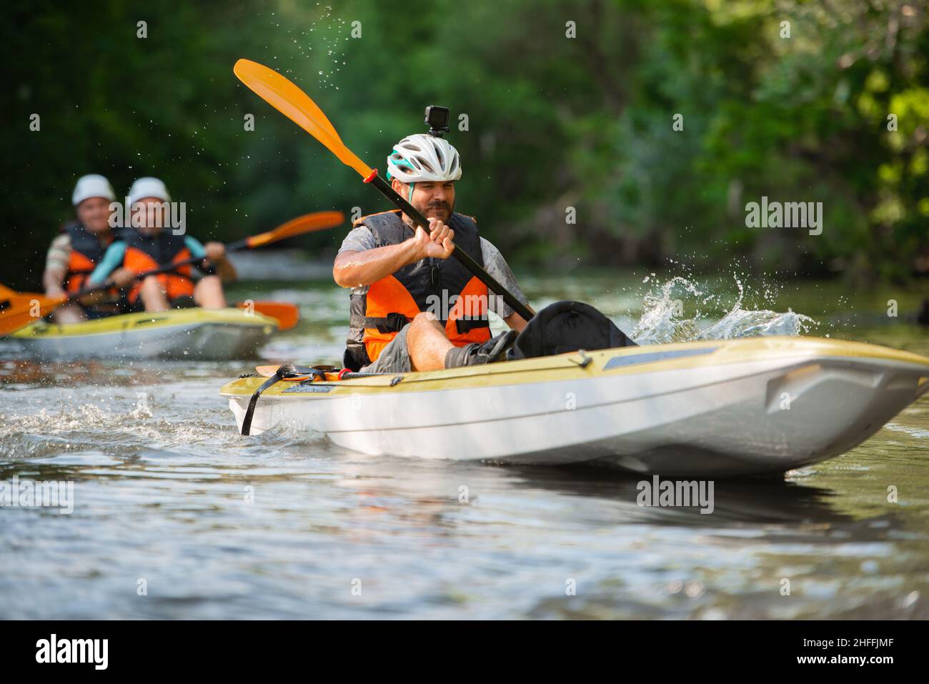 Portrait of fit and healthy senior kayaker racing with his friends ...