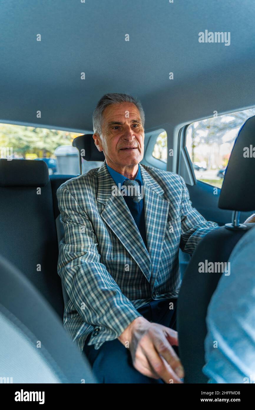 Senior and handsome businessman is getting a ride from his driver Stock ...