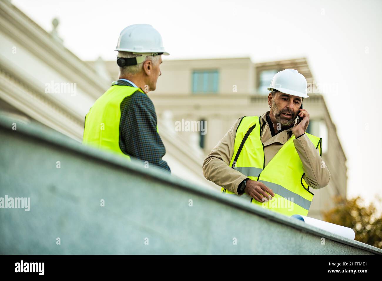 Business construction workers is talking with his clients on the phone ...