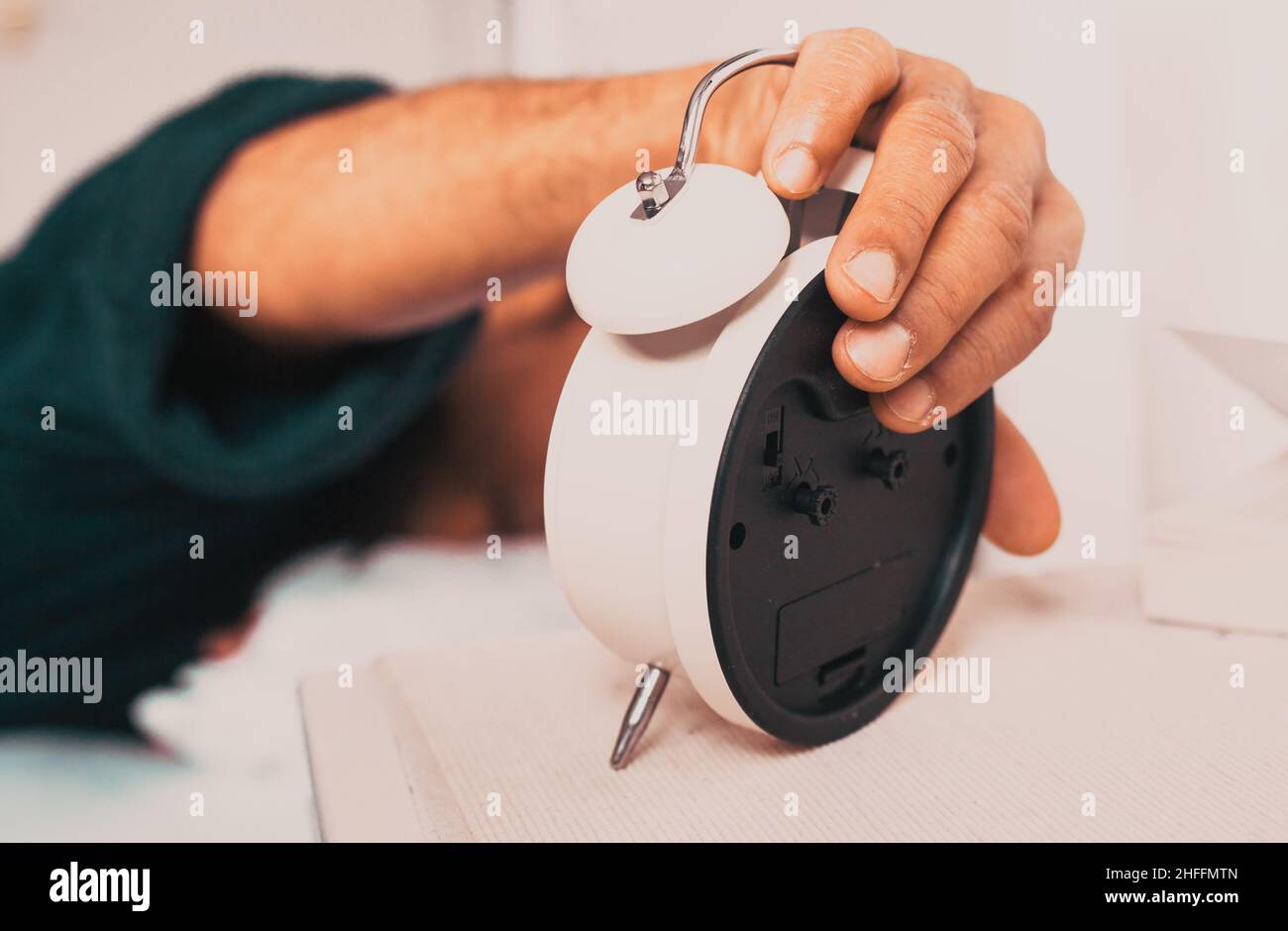 man closing alarm clock in the morning Stock Photo - Alamy