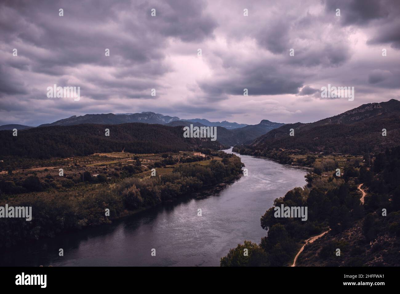 Curved river under a cloudy sky in Miravet town in Catalonia Stock ...