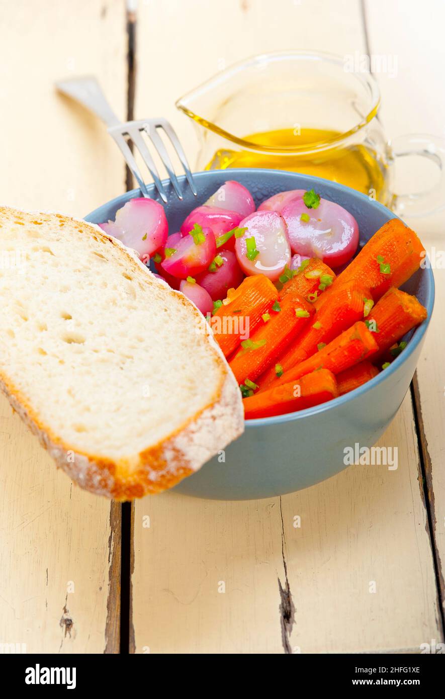 bowl of steamed root vegetable on a rustic white wood table Stock Photo ...