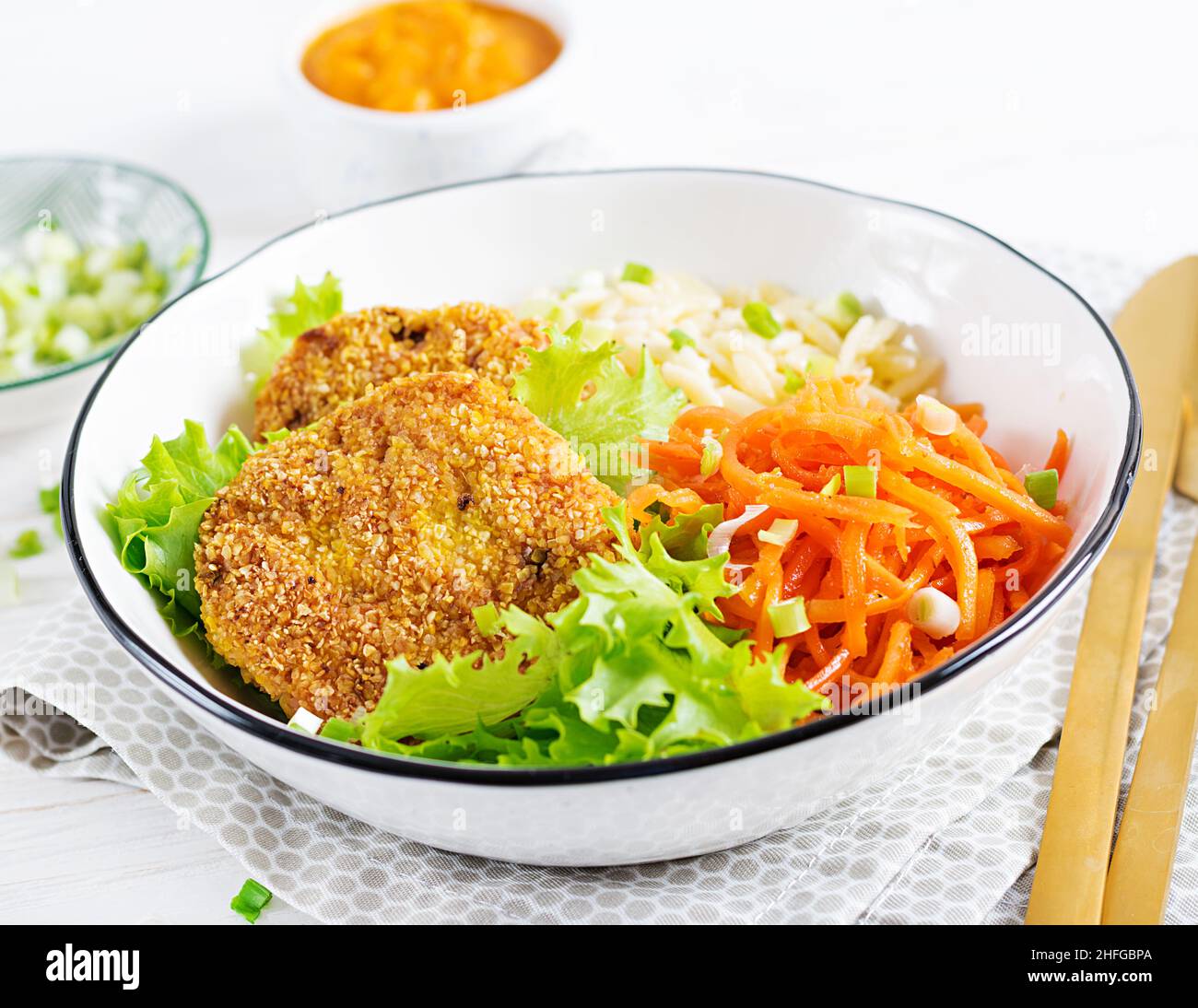 Orzo pasta, carrots and chicken burgers in white bowl. Risoni pasta ...
