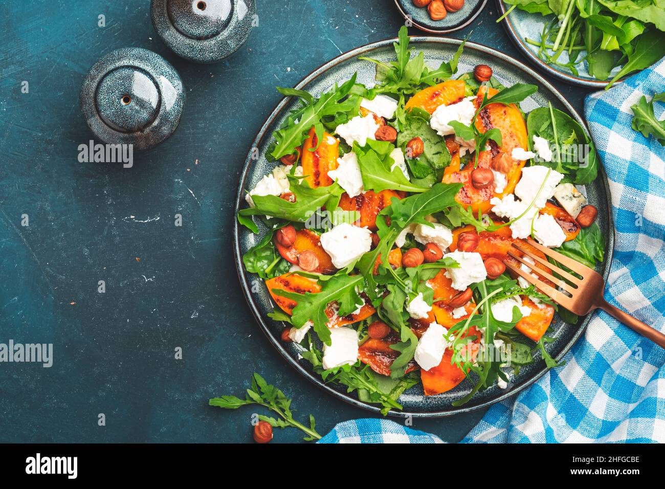 Summer salad with grilled peach with soft cheese, hazelnuts and arugula ...