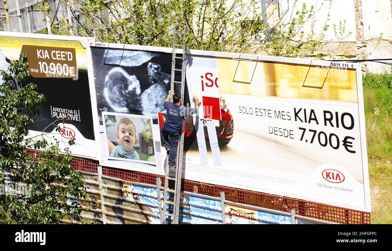 Man placing advertising poster on an advertising billboard in Barcelona ...