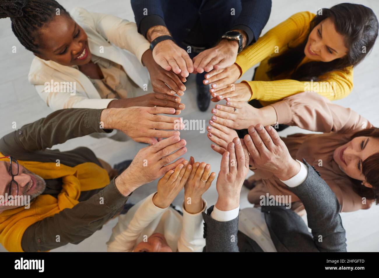 Top view of diverse team of happy business people joining their hands and smiling Stock Photo ...