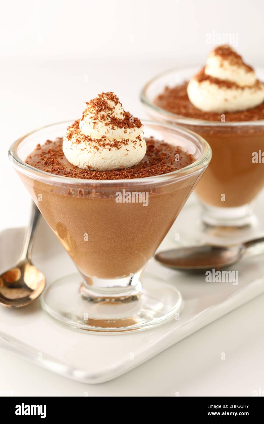 Chocolate mousse desserts in conical glass dishes on a white porcelain ...