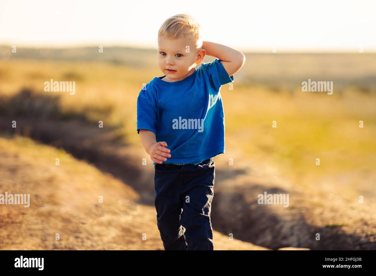 Happy little child boy running on the summer meadow in nature. Smiling ...