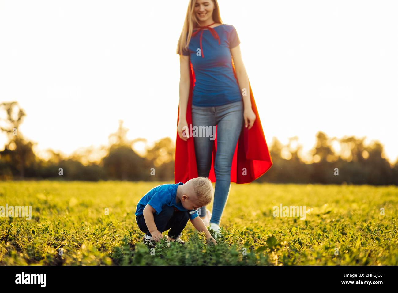 Happy family, Mom and her little son in superhero costumes, plant a ...