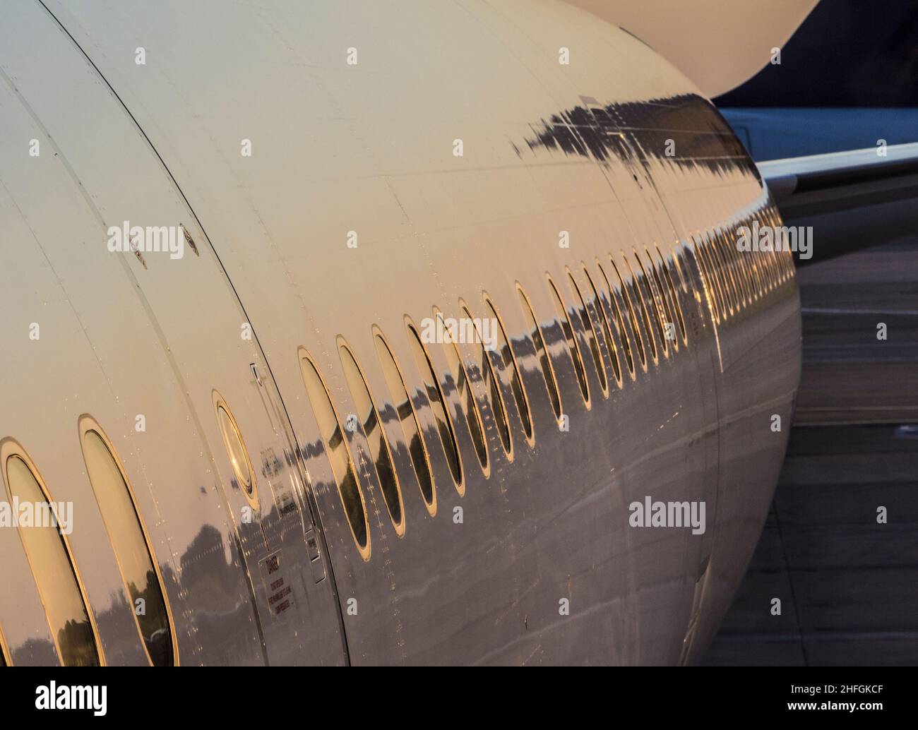 detail of aircraft with reflection of sunset in window and body Stock ...