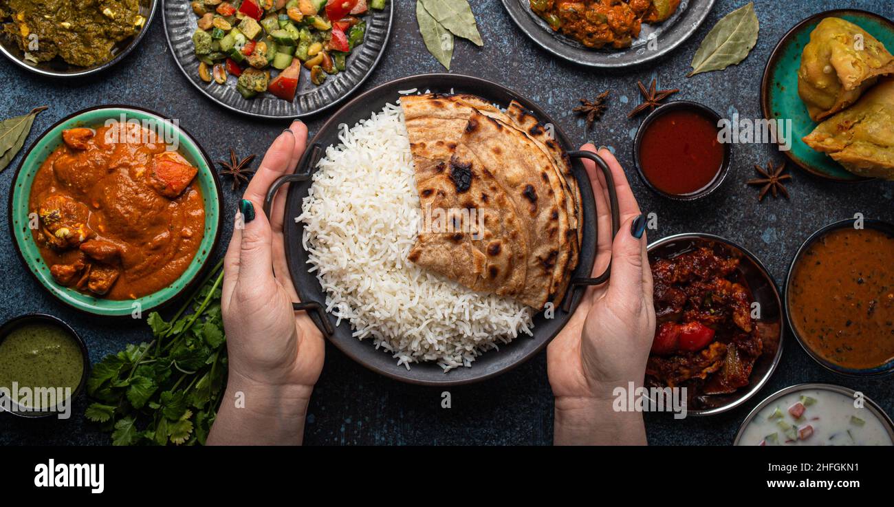 Assorted Indian ethnic food buffet on rustic concrete table from above ...
