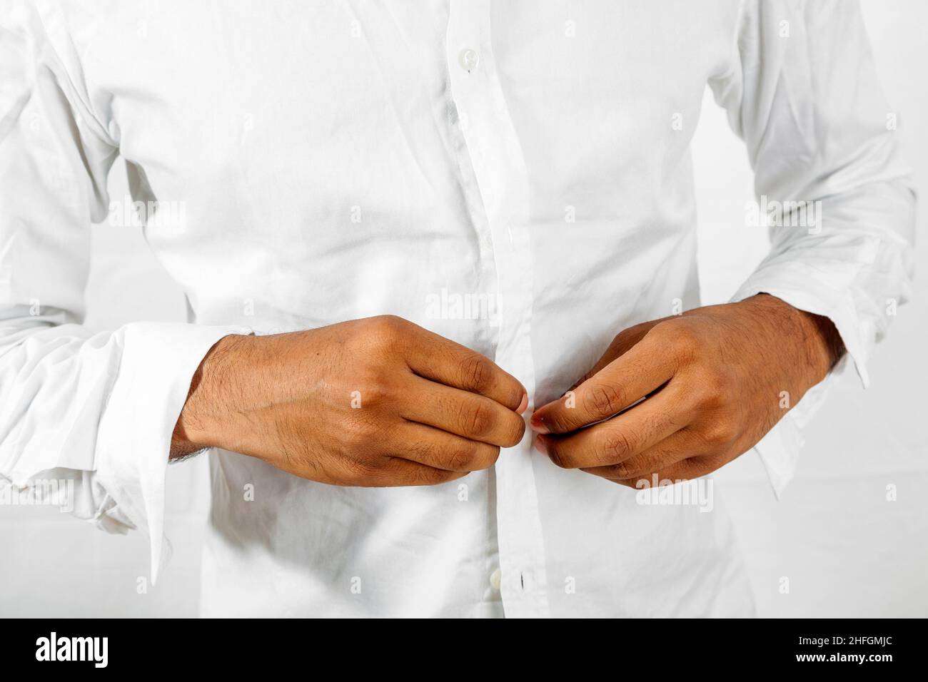 man buttoning his shirt Stock Photo - Alamy