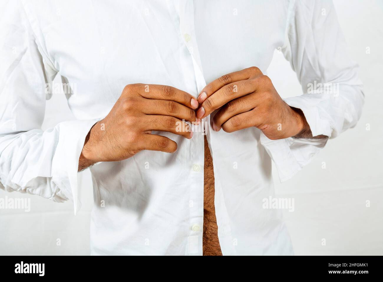 man buttoning his shirt Stock Photo - Alamy