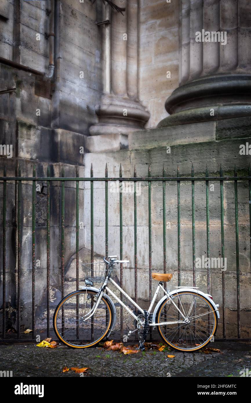 White bick leaning against a wrought iron fence Stock Photo - Alamy