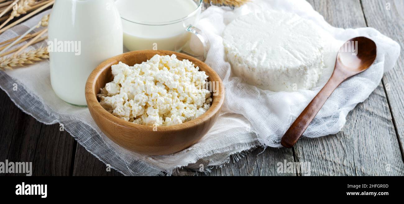 Milk in a cup and milk products on a dark wooden background. Selective ...