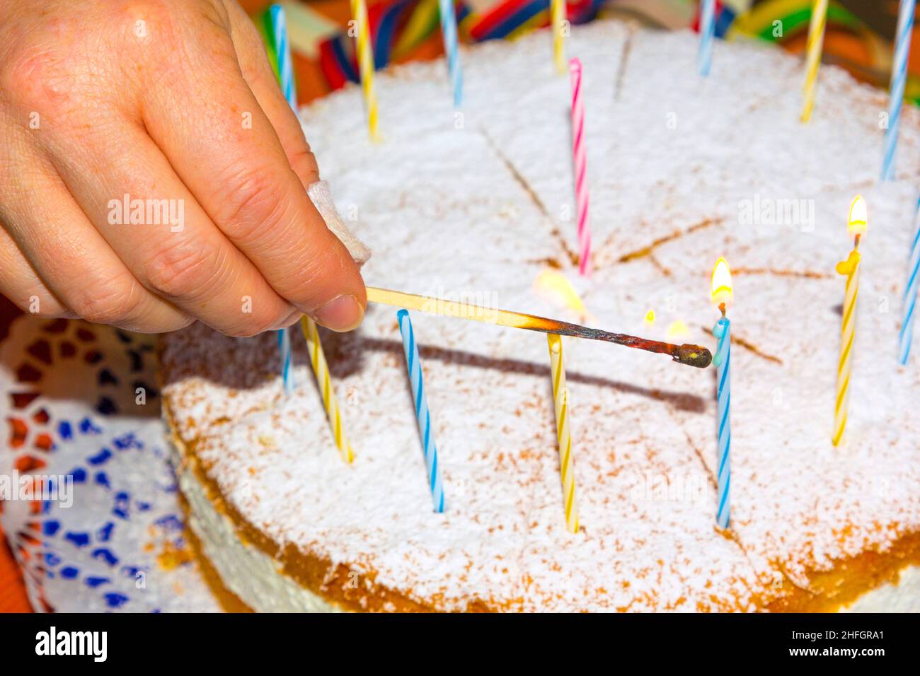 lighting the birthday candles on the cake Stock Photo - Alamy