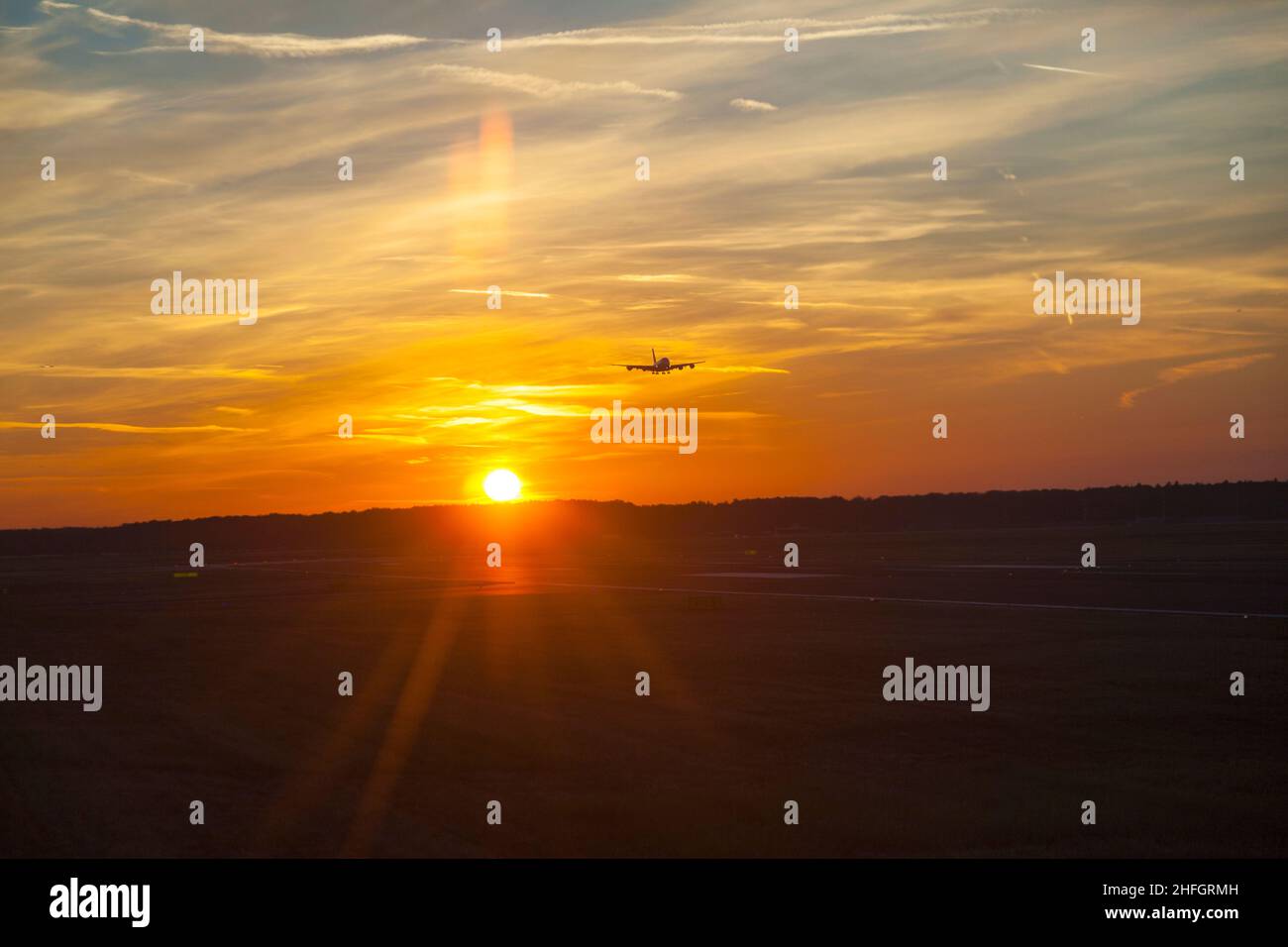 aircraft landing in sunset with colorful sky Stock Photo - Alamy