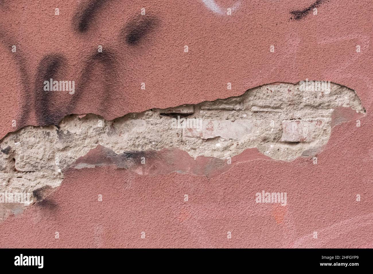 Crumbling peeling plaster from the old facade of a city house broken ...