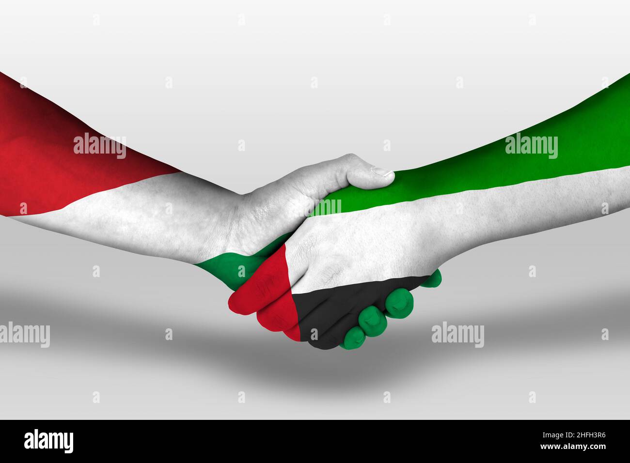Handshake between united arab emirates and hungary flags painted on ...
