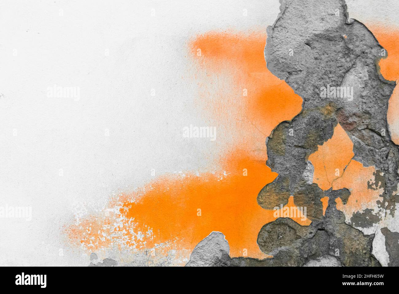 Crumbling peeling white plaster from old wall surface with orange paint ...