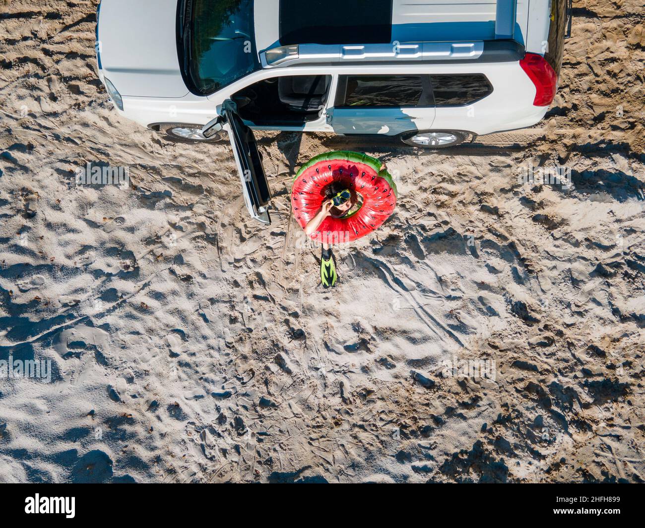 overhead top view happy woman getting out from the car in flippers with ...