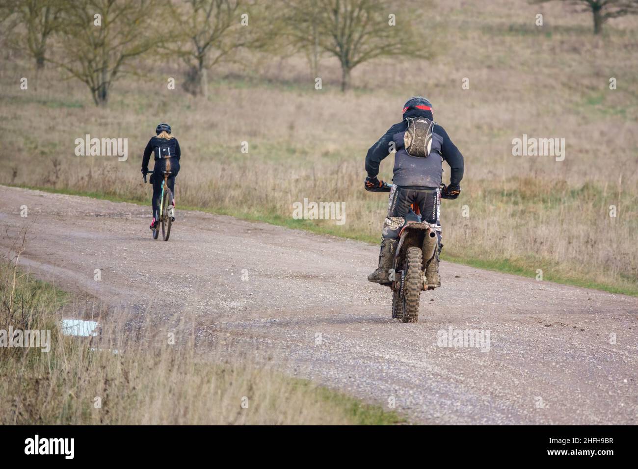 a motor cyclist (biker) riding his off-road motorbike along a stone ...