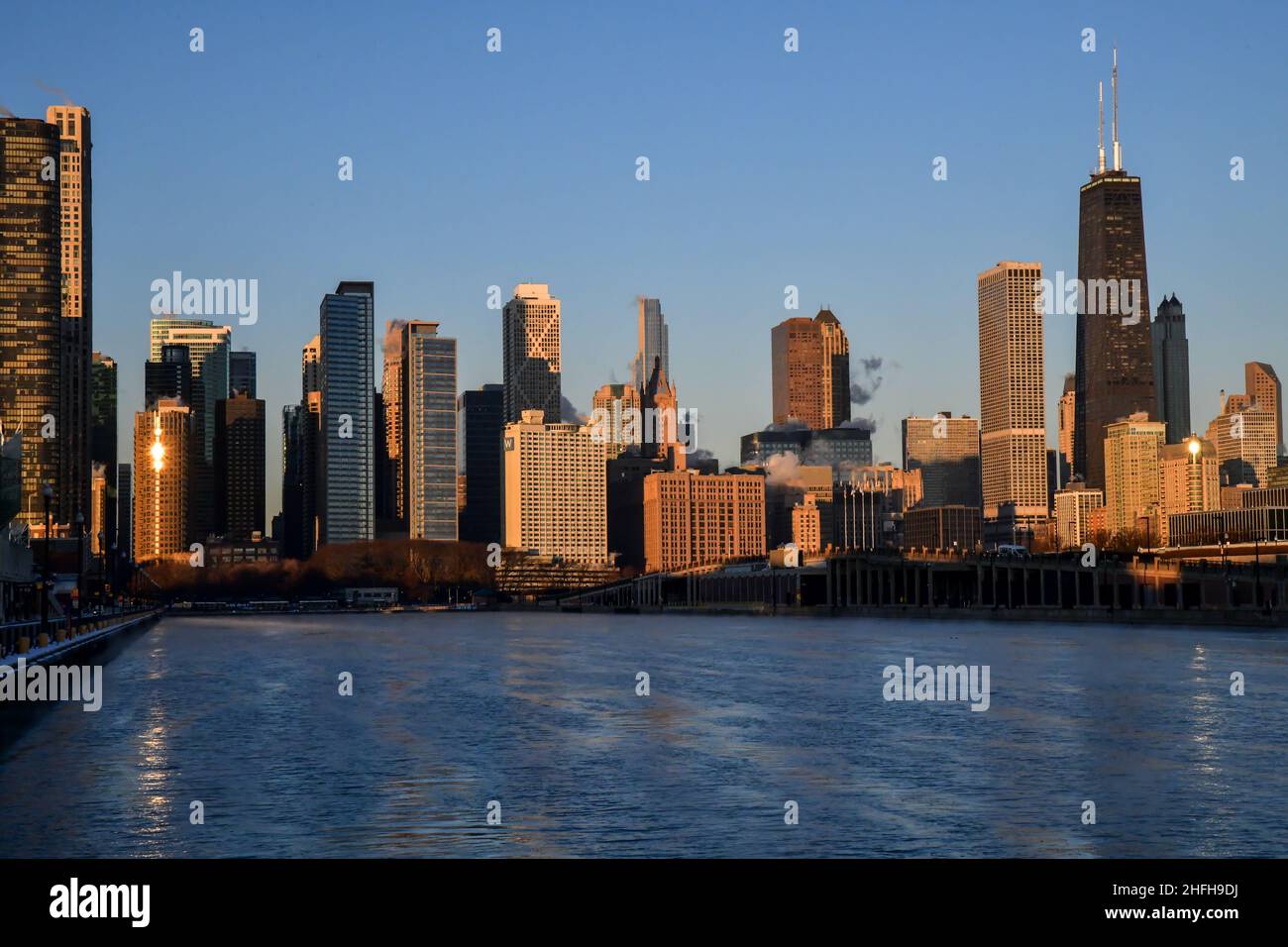 Chicago urban skyline along the water at sunrise in winter Stock Photo ...