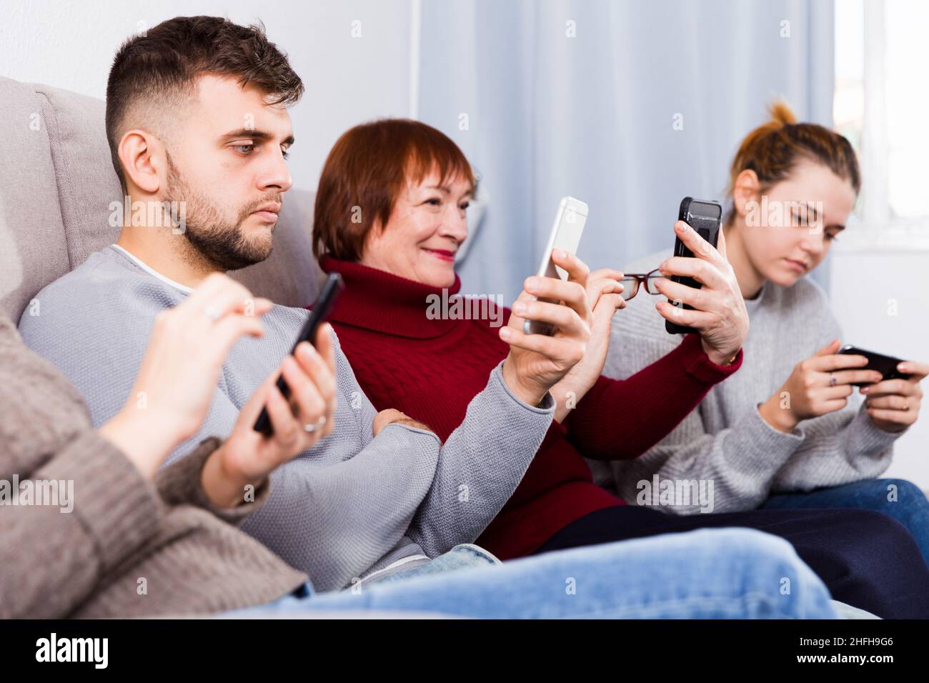 Modern family with smartphone at home Stock Photo - Alamy
