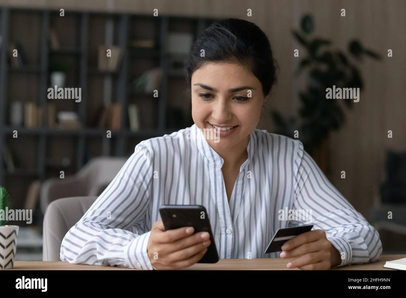 Smiling beautiful millennial Indian woman shopping online Stock Photo ...