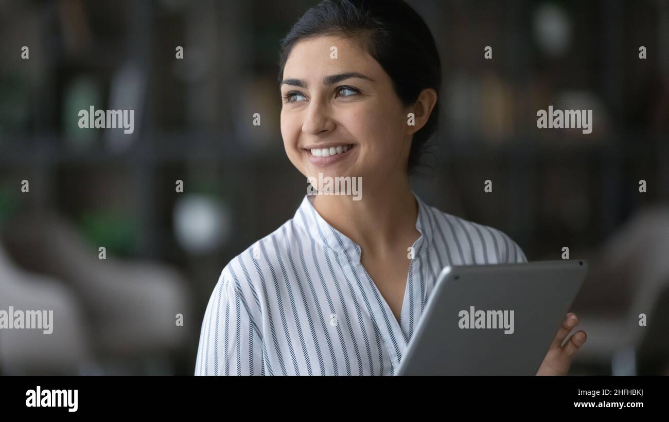 Happy dreamy young Indian woman using digital tablet Stock Photo - Alamy