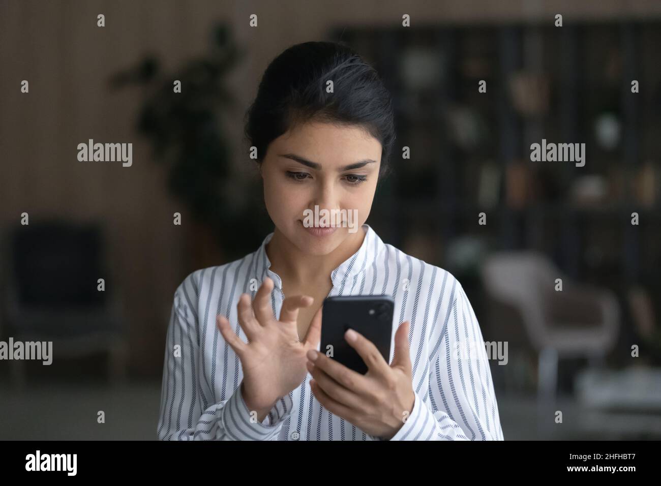 Happy young Indian ethnicity woman using cellphone Stock Photo - Alamy