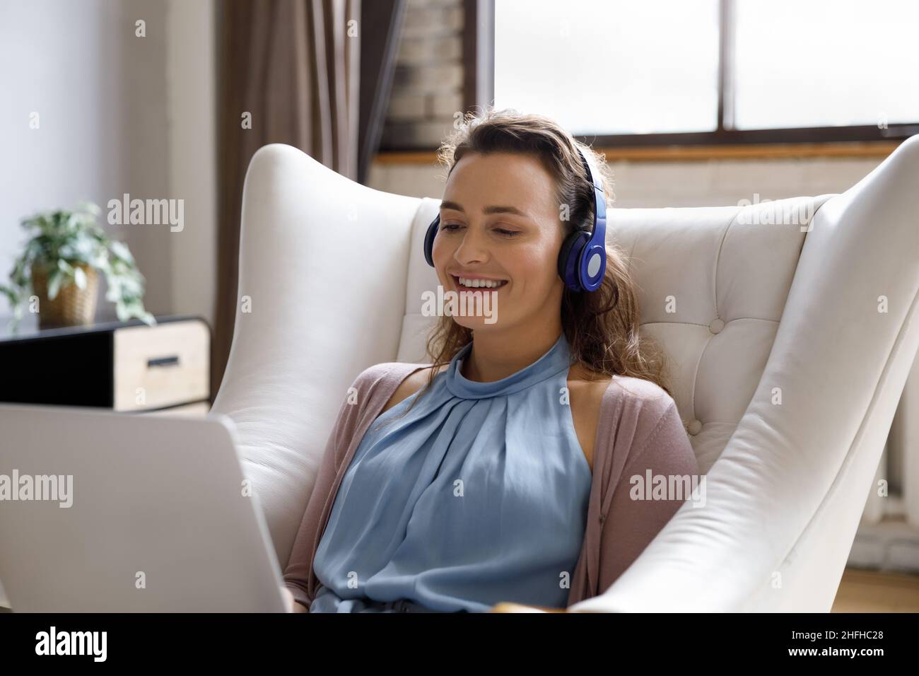 Joyful millennial woman in headphones using computer Stock Photo - Alamy