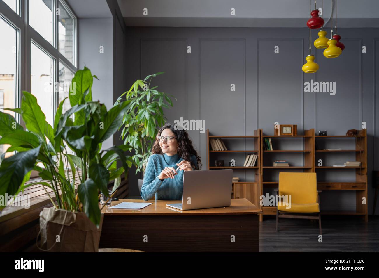 Happy freelancer female in coworking space look in window after ...