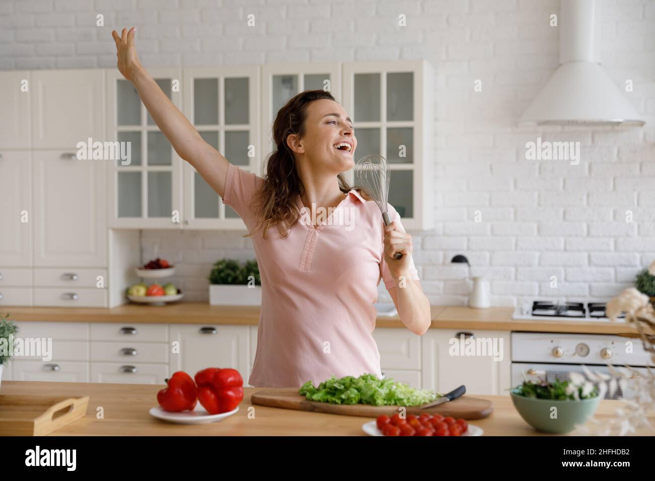 Happy young woman having fun, cooking in modern kitchen Stock Photo - Alamy